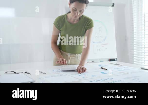 Professional female executive analyzing financial data, pointing toward ...