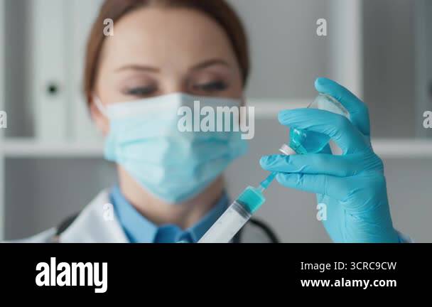 A laboratory technician meticulously measures and prepares blue liquid ...