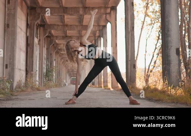 A skilled woman performs fluid yoga dance poses, showcasing her ...