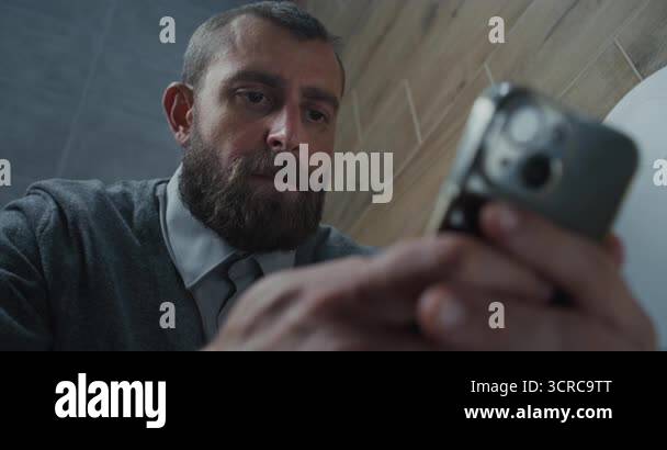 Close Up of Male Office Worker Sitting on Toilet and Scrolling ...