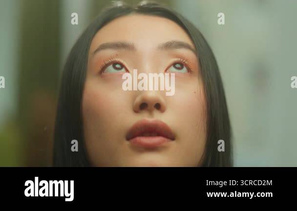 Close up Asian woman looking up thinking inspired dreaming portrait ...