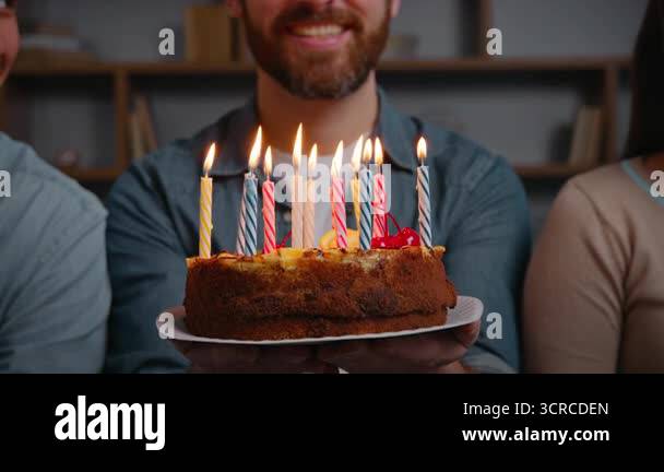 Close up unrecognizable man holding birthday cake with burning candles ...