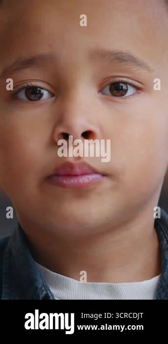Close up serious African American boy waving hello hi greeting at home ...
