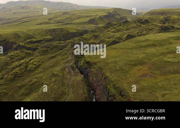 Sweeping aerial view of Iceland's moss covered cliffs, deep ravines ...