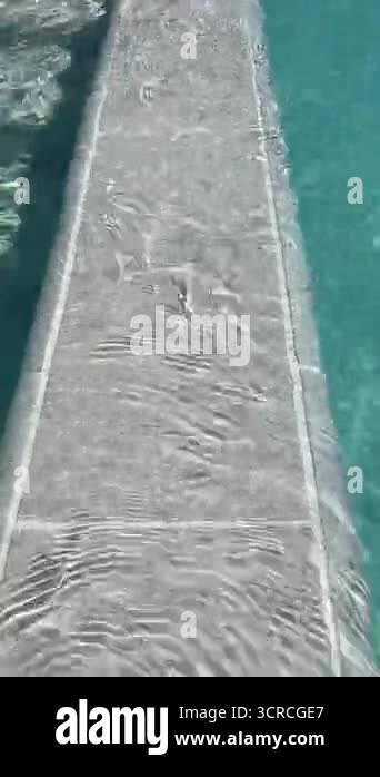 Sunlight reflecting on steps and drain of a clean swimming pool ...