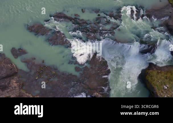 Dynamic aerial view of a waterfall in Iceland with water flowing over ...