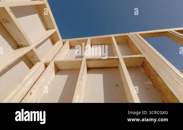 Wooden unfinished walls under clear sky on the construction development ...