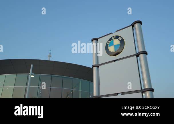 Illuminated sign post of BMW dealership on twilight blue sky background ...