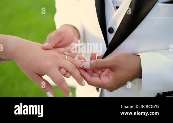 The groom puts on the wedding ring on the bride finger, at the wedding ...