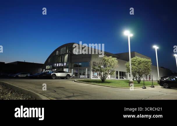 Exterior of Tesla dealership with sunny evening sky. The dealership ...