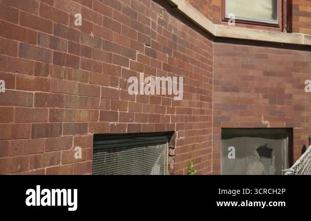 Old brick residential building wall with visible wear and aging. The ...