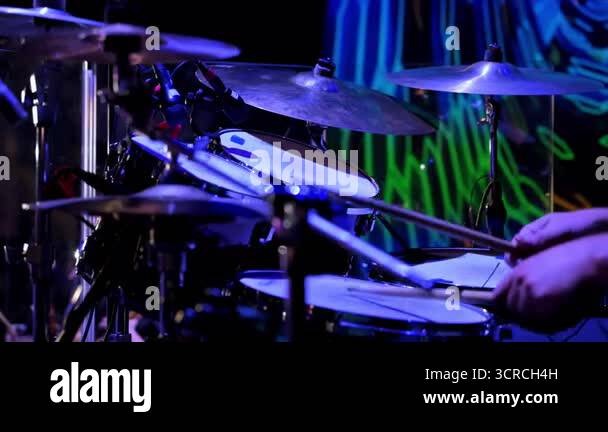 Live concert performance, a drummer energetically playing on stage ...
