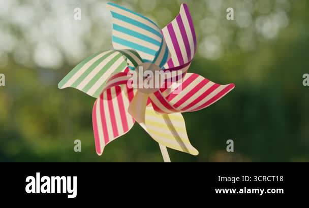 Colorful pinwheel toy spins fast in wind and rotates in smooth circles ...