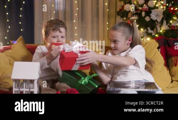 Cheerful siblings pretend to have playful battle using holiday presents ...