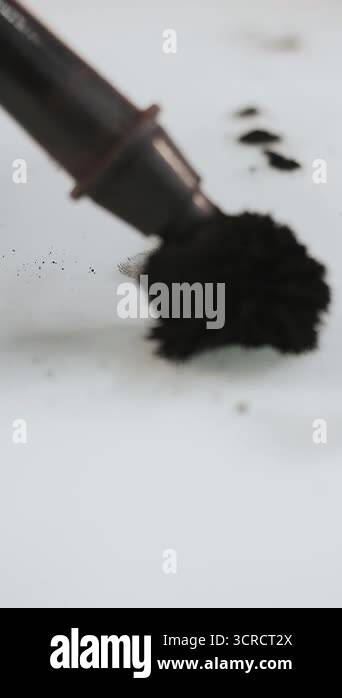 A forensic scientist runs a brush with decteloscopy powder over a ...