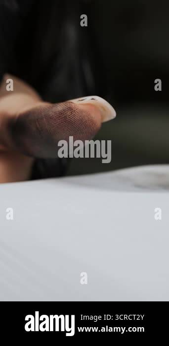 Taking fingerprints from a womans hand. Biometrics of female fingerprints on a sheet of paper ...