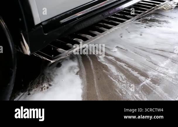Detailed view of a vehicle side step being thoroughly washed. Abundant ...
