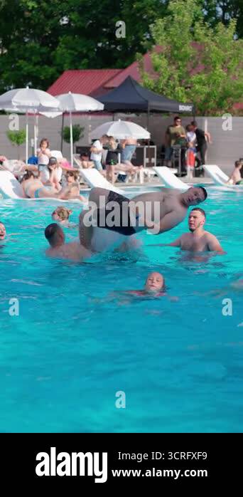 Crowded outdoor swimming pool with people relaxing and playing in water ...