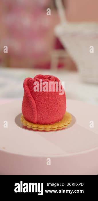 Gourmet rose-shaped red mousse dessert on golden biscuit base, luxury ...