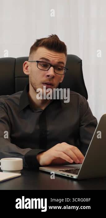 Tired man sitting in front of laptop, taking off glasses and rubbing ...