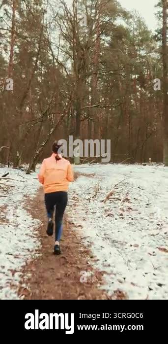 Female athlete running in winter park. Woman wearing sports clothing ...