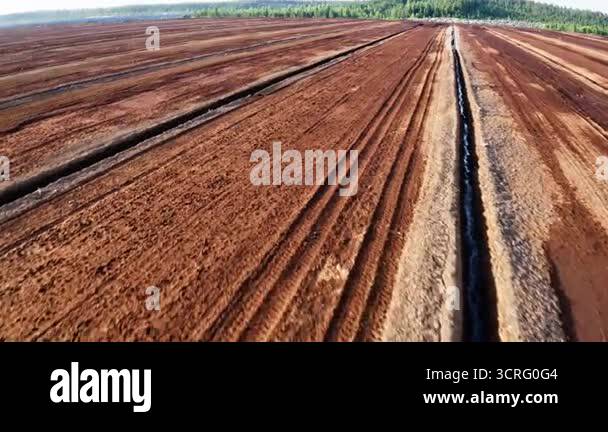 Drone flight forward. Aerial view of peat extraction bog. Large peat ...