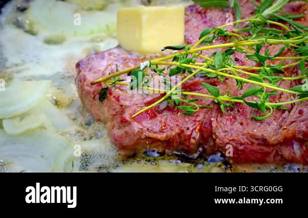 Close-up. Food preparation. A rare piece of steak is being cooked on a ...