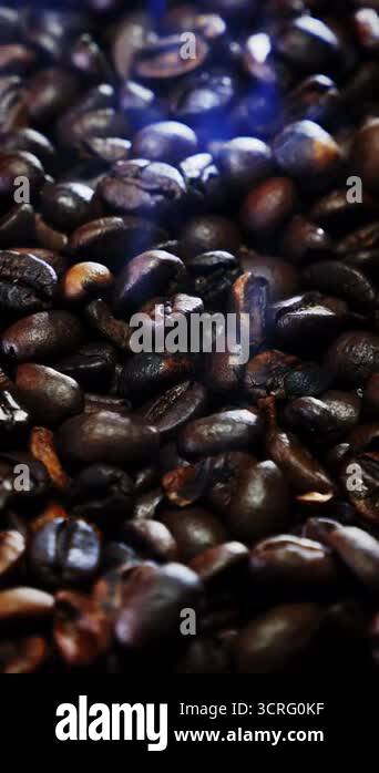 Fragrant coffee beans with smoke, close up. Arabica coffee grains are ...