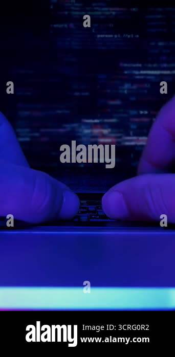 Person is working in dark office in front of laptop computer, writing ...