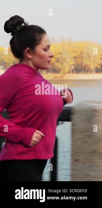 Beautiful sportive female wearing violet sportswear running near city ...