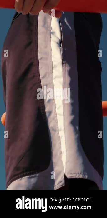Man exercising on uneven bars on outdoors ground, close up of hands and ...