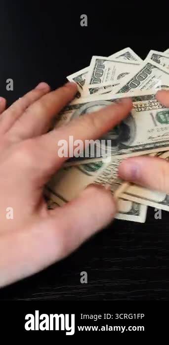 Man is counting money sitting in modern office. Vertical video ...