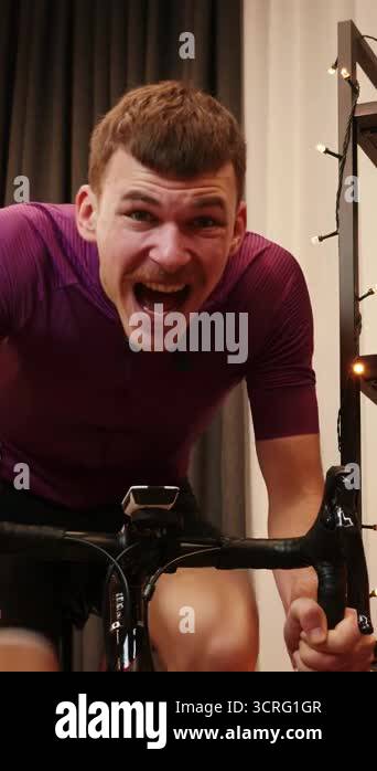 Professional cyclist finishes online cycling race on stationary bicycle ...