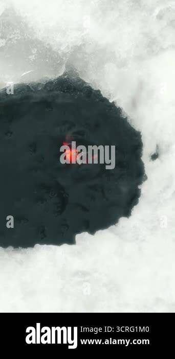 Winter fishing. Close up of ice hole with fishing rod in it. Fisherman ...