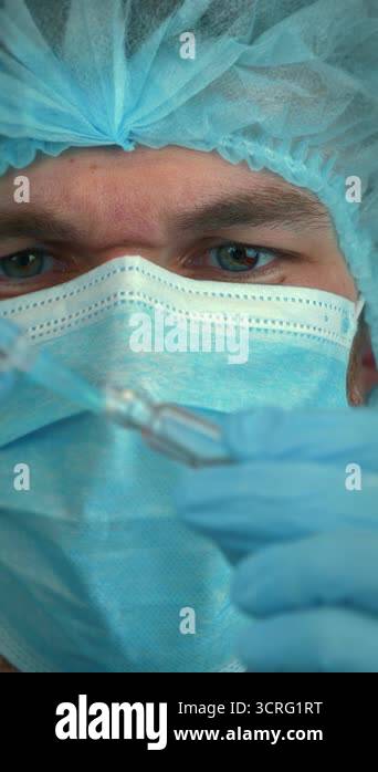 Portrait of man in protective medical clothes, gloves and face mask is ...