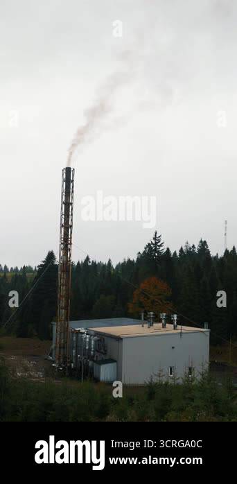 High pipe with black smoke against mountains landscape. Plant smoke ...