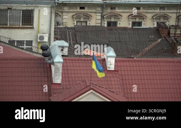 A blue and yellow Ukrainian flag flutters wind skull-like roof building ...
