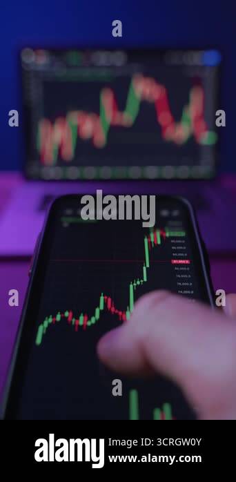 Close up of trader holding smartphone, using trading application analyzing crypto and stock ...