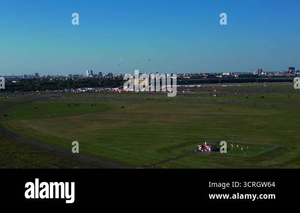 thousands of Berliners enjoying the giant kite festival on a sunny day ...