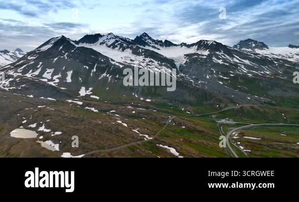 Snowy mountain peaks in Alaska with green valleys. High snow-covered ...