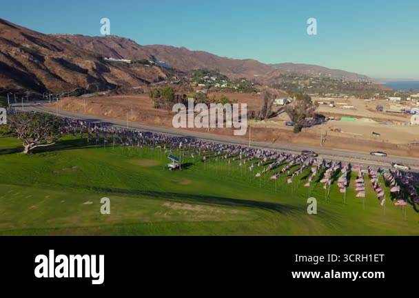 Aerial footage shows vibrant flags flowing on a hillside near the coast ...
