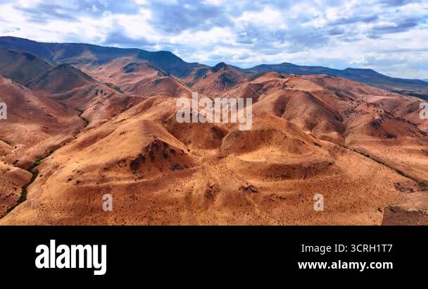 Thick clouds cover the sky over the arid mountainous landscape. Dry ...