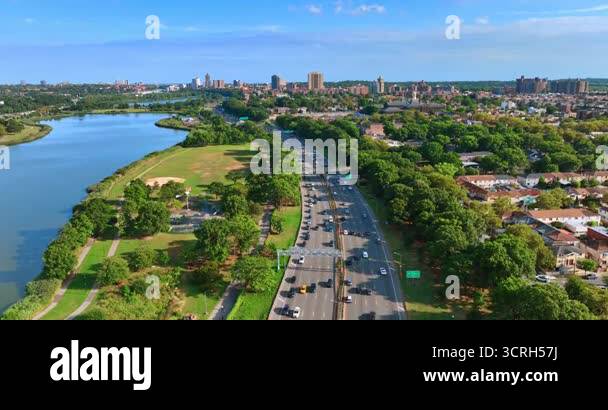 Busy highway with numerous cars along the pond in the park. Drone ...