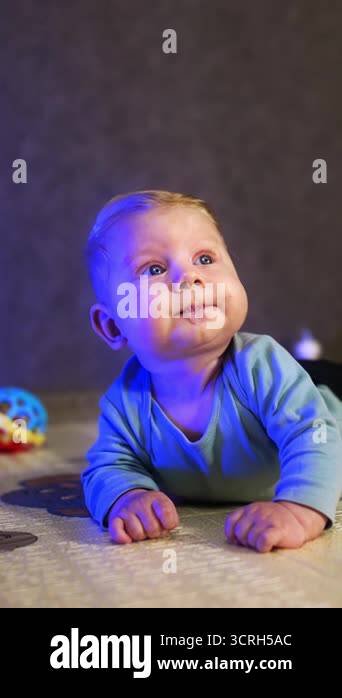 Little infant baby with fair hair lies on his belly. Peaceful baby boy ...
