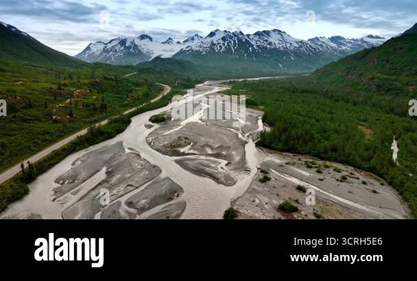 Delta of shallow river with green rocky waterfronts. Spectacular snow ...