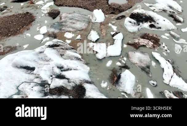 Footage over the river with grey dark water and ice boulders in. Ice ...