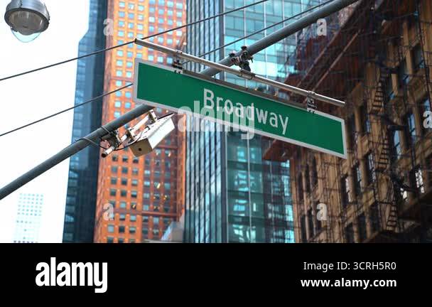 Broadway sign and skyscrapers in New York City. A green Broadway street ...