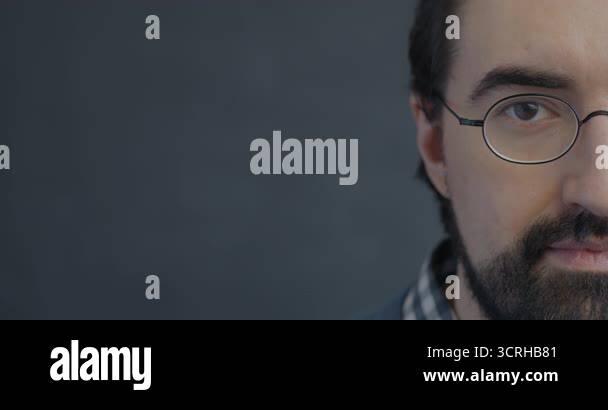 Close-up slow motion of serious Middle Eastern man half face looking at ...