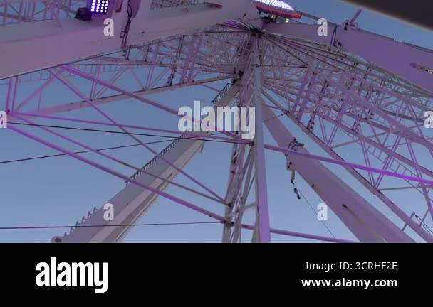 Ferris wheel is spinning. Blue sky background. Attraction entertainment ...