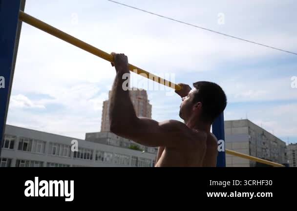 Sportsman performing dynamic pull-up workout, showcasing strength and ...